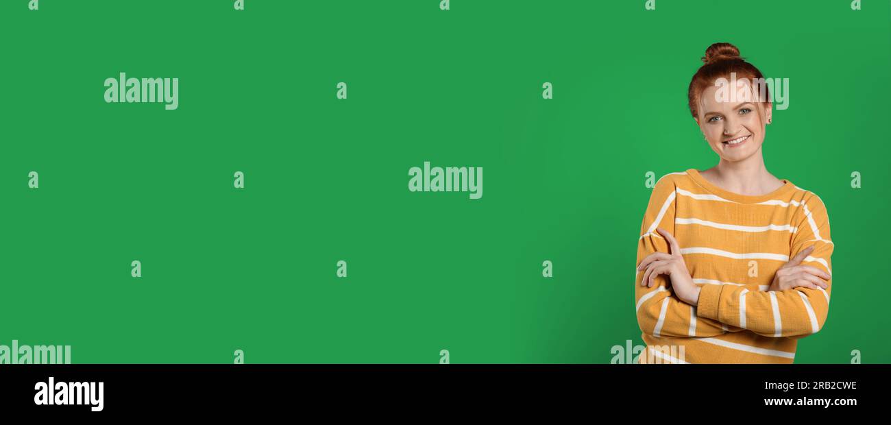 Chroma key compositing. Happy young woman with red hair against green ...