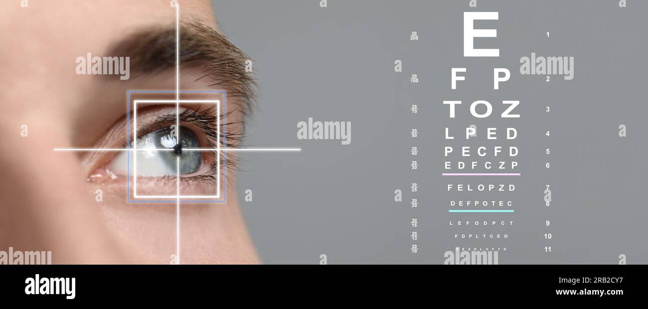 Vision test chart and laser reticle focused on man's eye against light ...