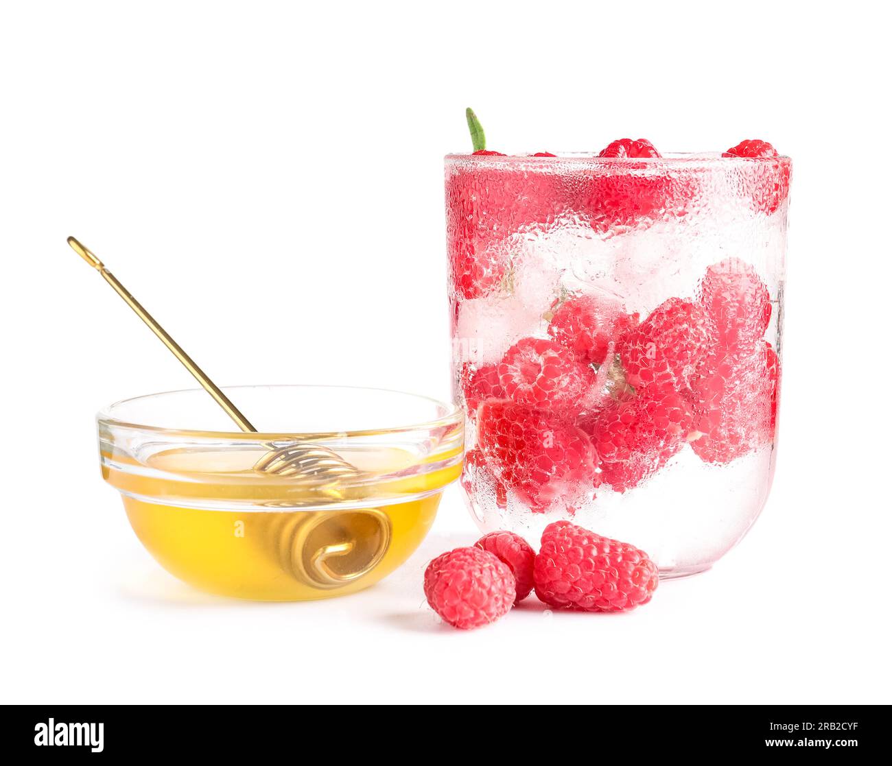 Glass of fresh raspberry lemonade and bowl with honey on white ...