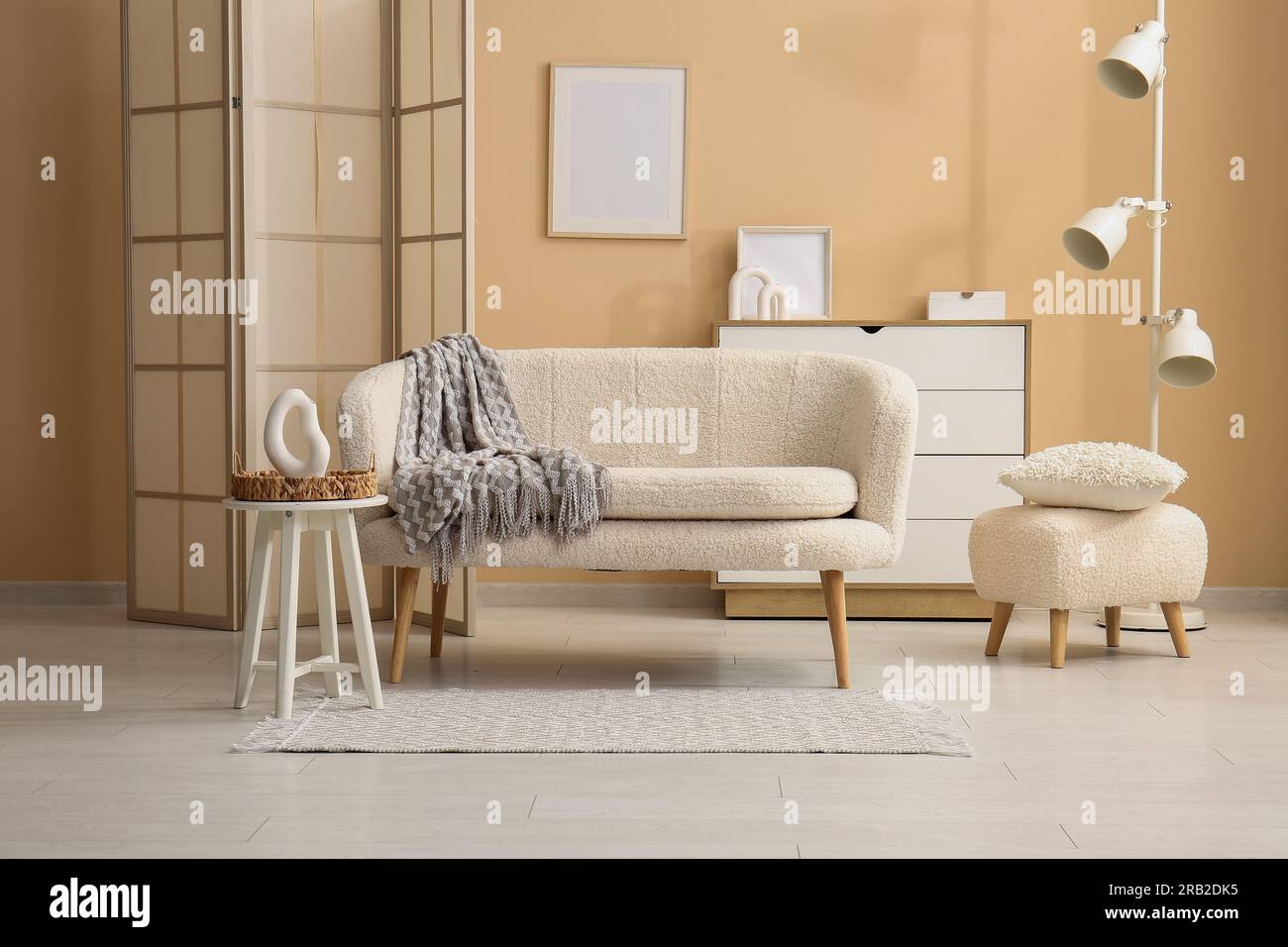 Modern living room interior with white sofa, ottoman and folding screen ...