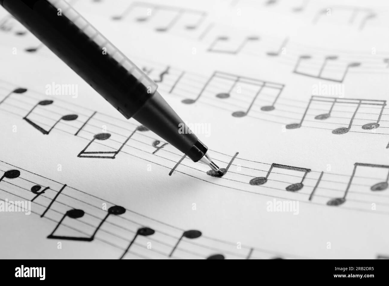 Writing musical notes with pen on sheet of paper, closeup view Stock ...