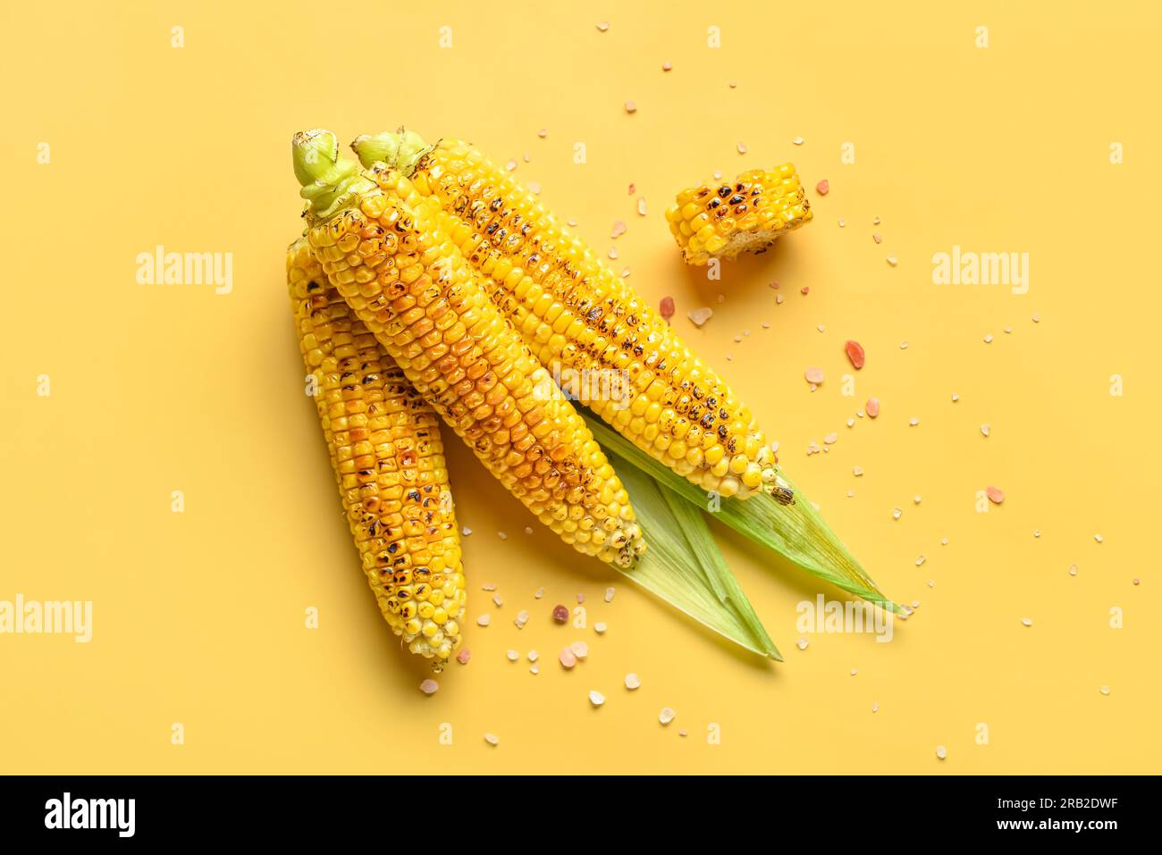 Tasty grilled corn cobs on yellow background Stock Photo - Alamy