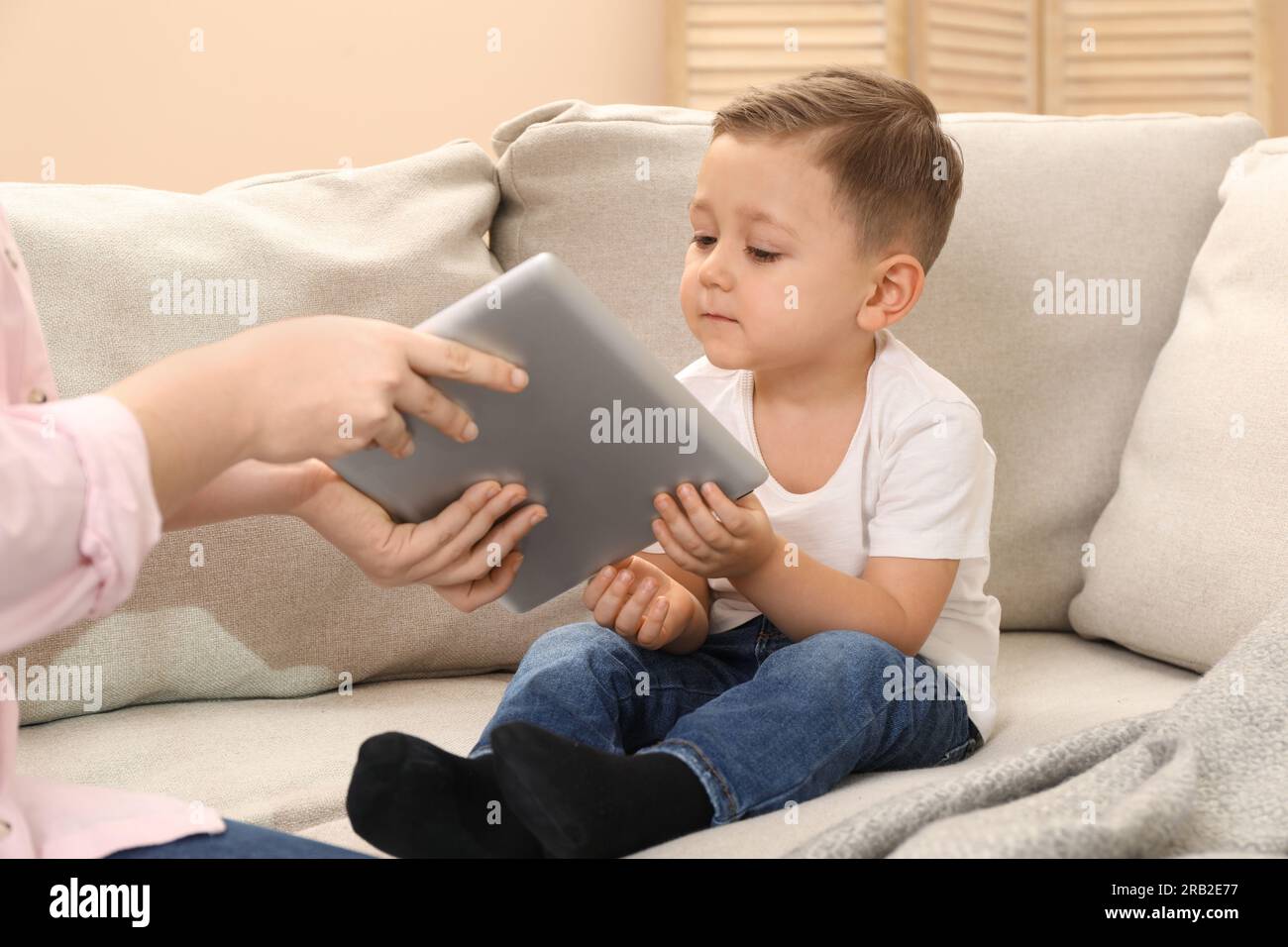Internet addiction. Mother taking away tablet from her little son on ...