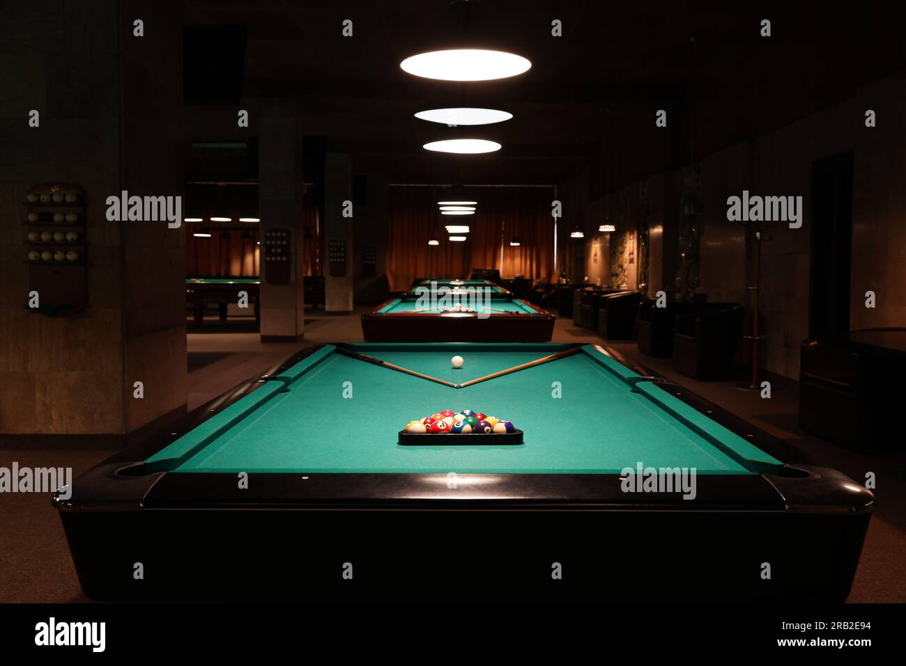 Billiard tables with balls and cues in club Stock Photo - Alamy