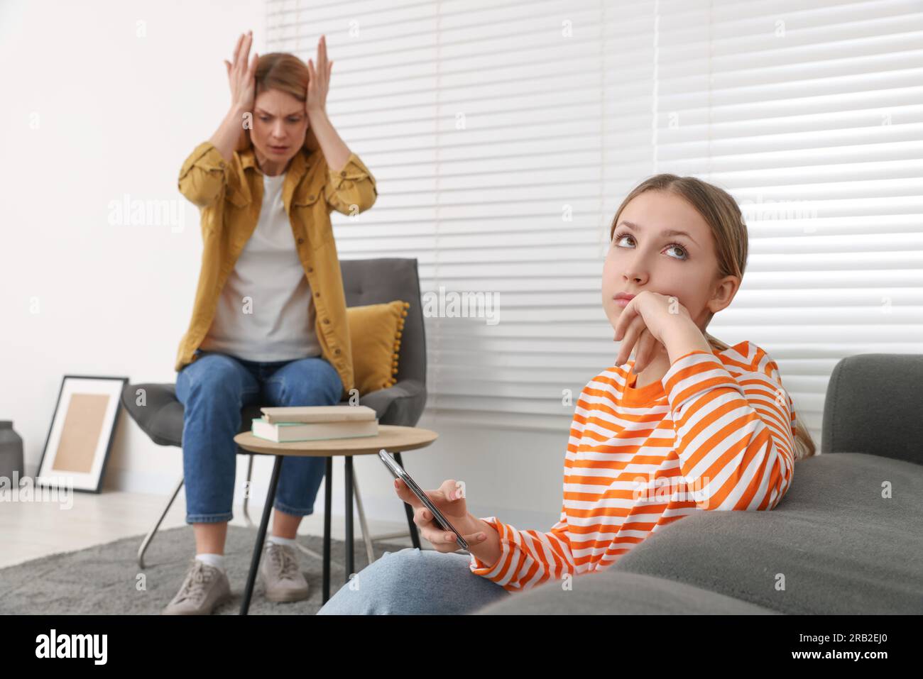 Teenage daughter with smartphone ignoring her mother at home Stock Photo - Alamy