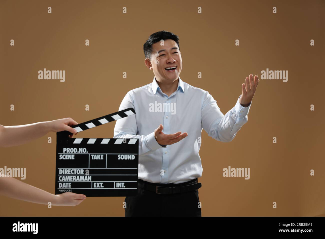 Happy asian actor performing while second assistant camera holding ...