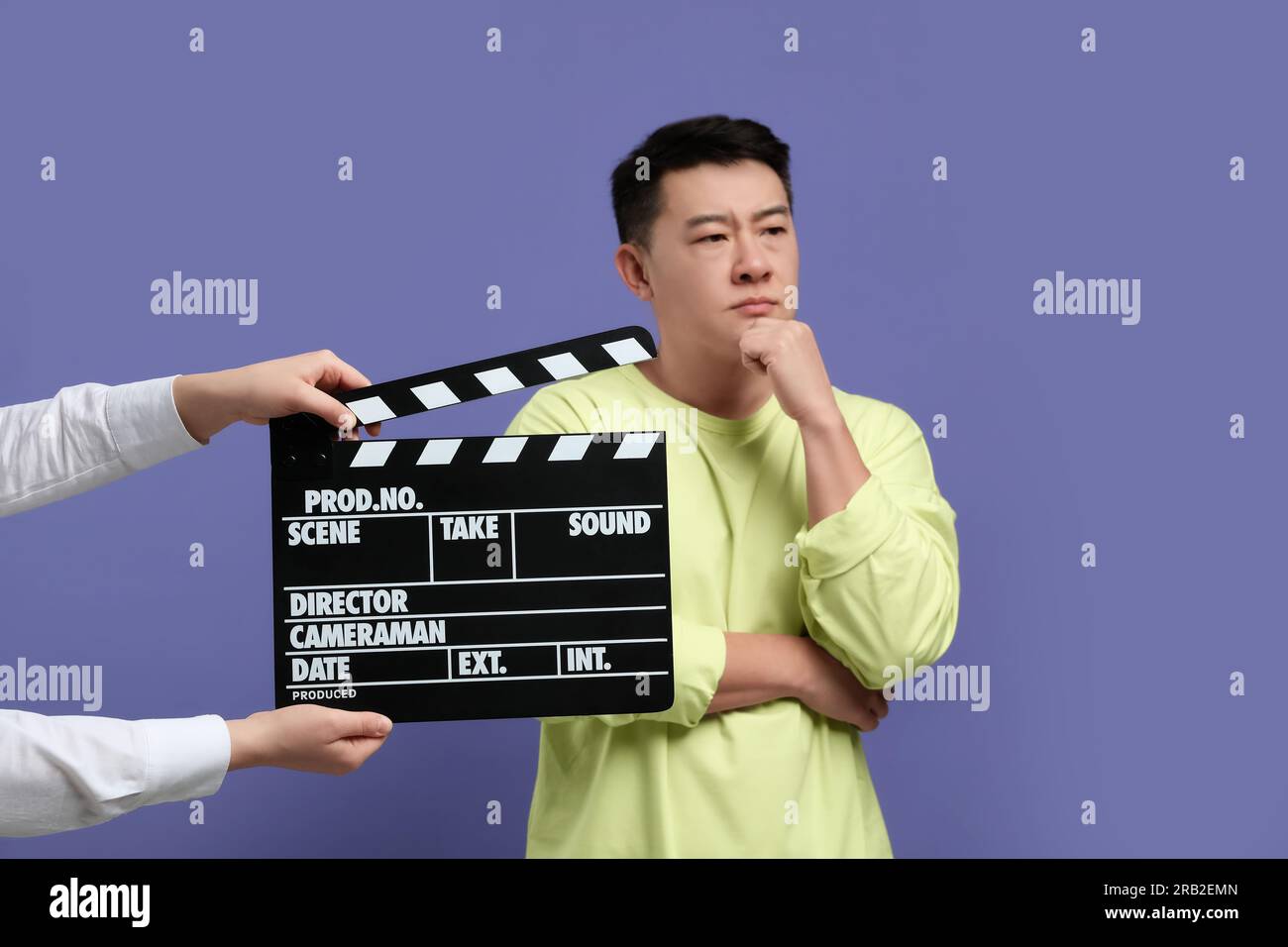 Asian actor performing while second assistant camera holding ...