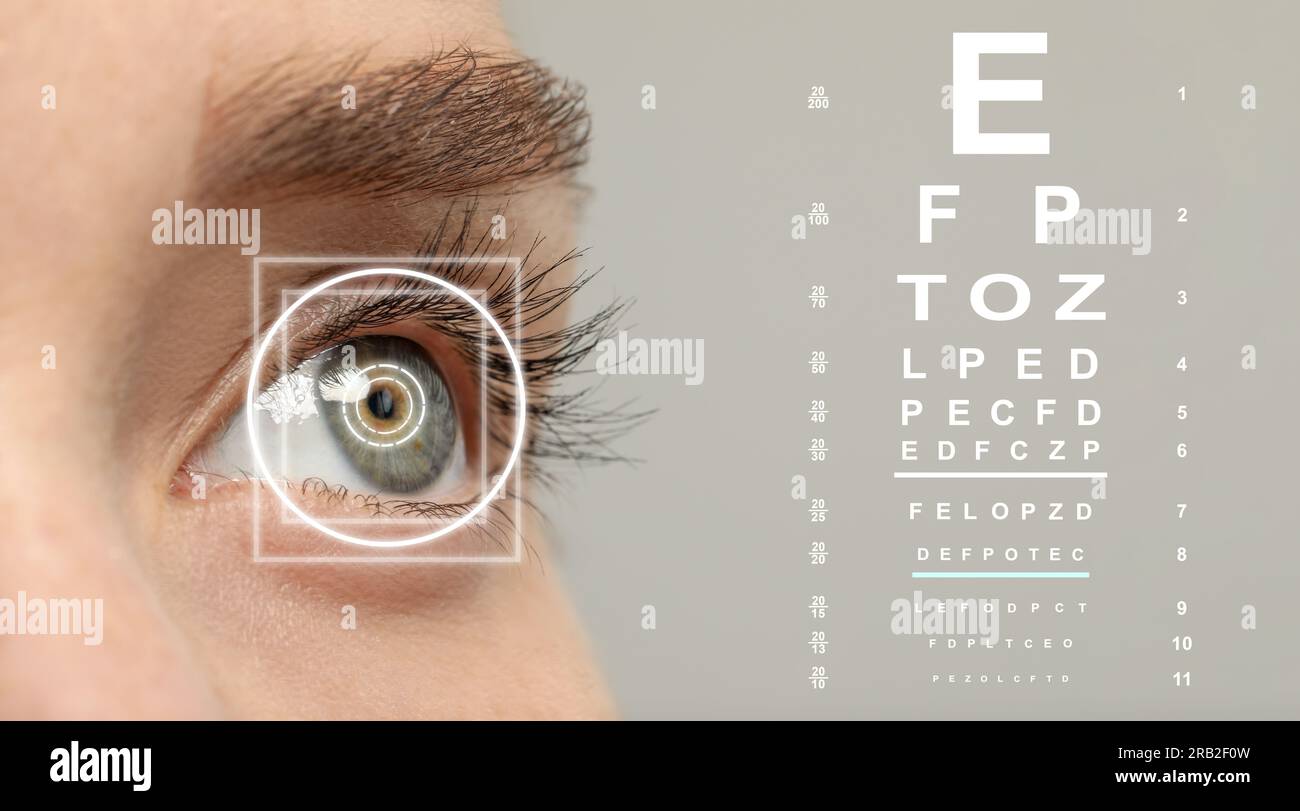 Vision test chart and laser reticle focused on woman's eye against ...
