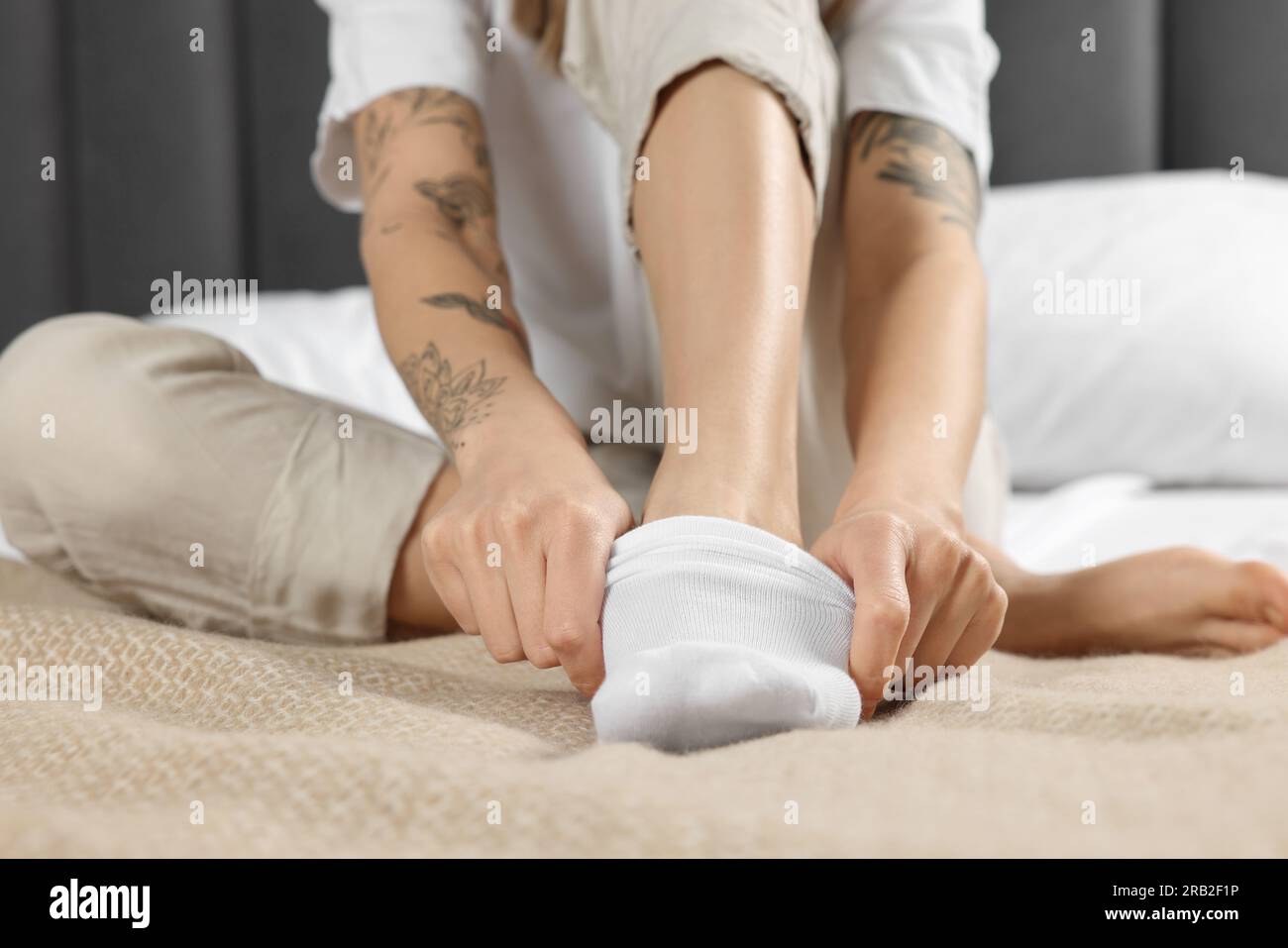 Woman putting on white socks in bedroom, closeup Stock Photo - Alamy
