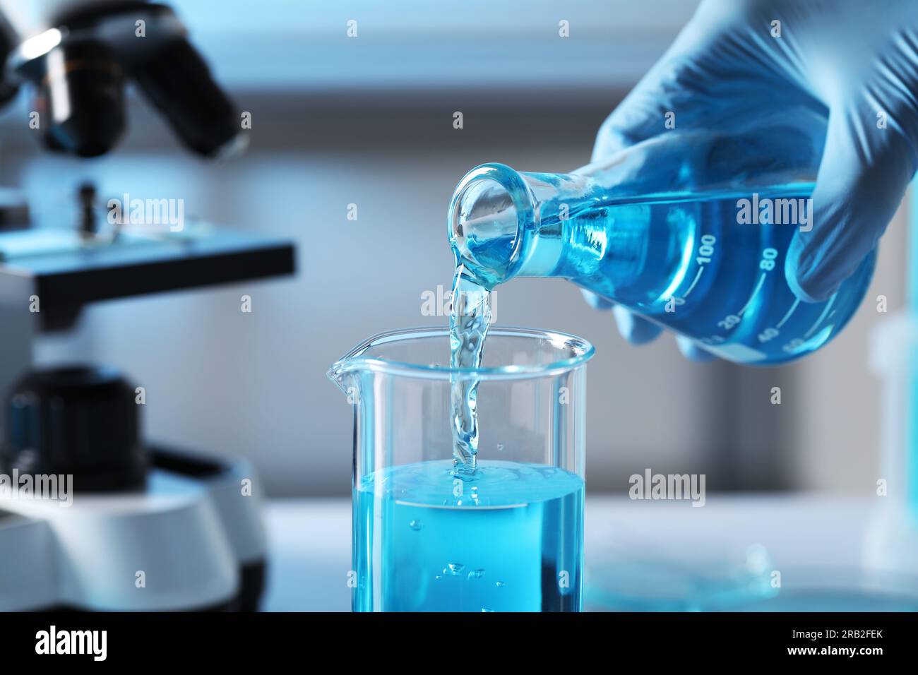 Scientist pouring light blue hi-res stock photography and images - Alamy