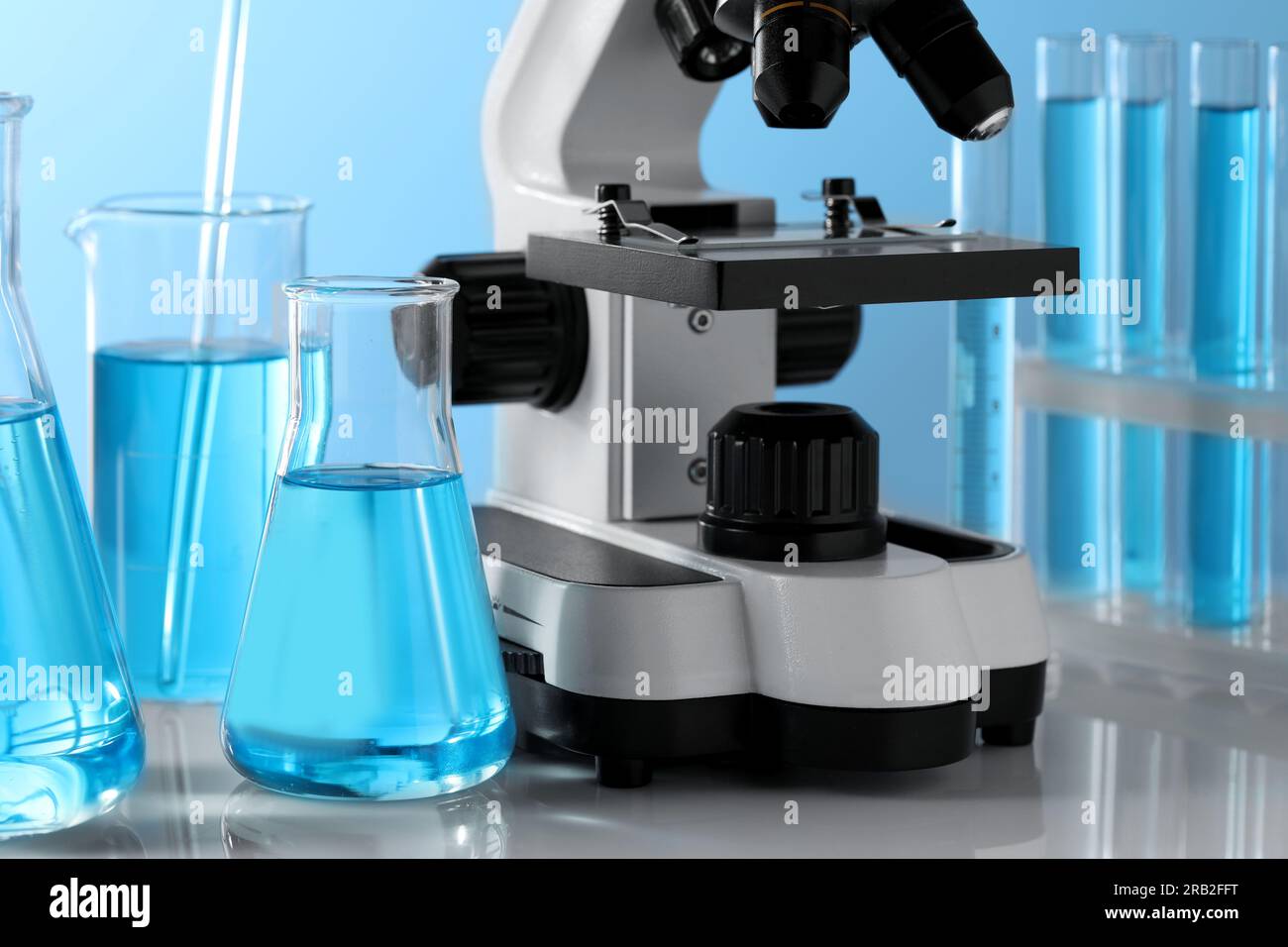 Different laboratory glassware, test tubes with light blue liquid and ...