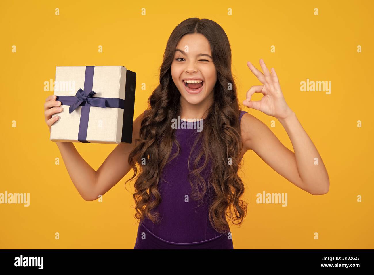 Funny face. Teenager kid with present box. Teen girl giving birthday ...