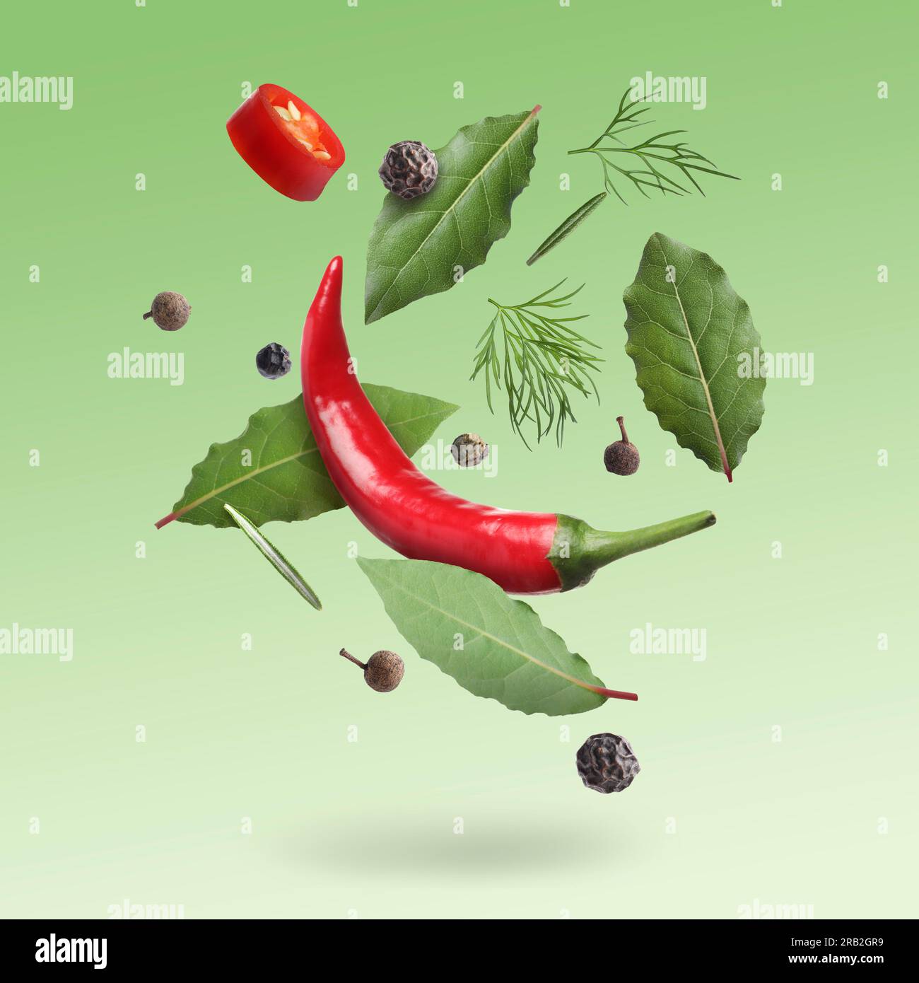 Bay leaves, rosemary, dill, black and fresh red hot peppers falling on ...