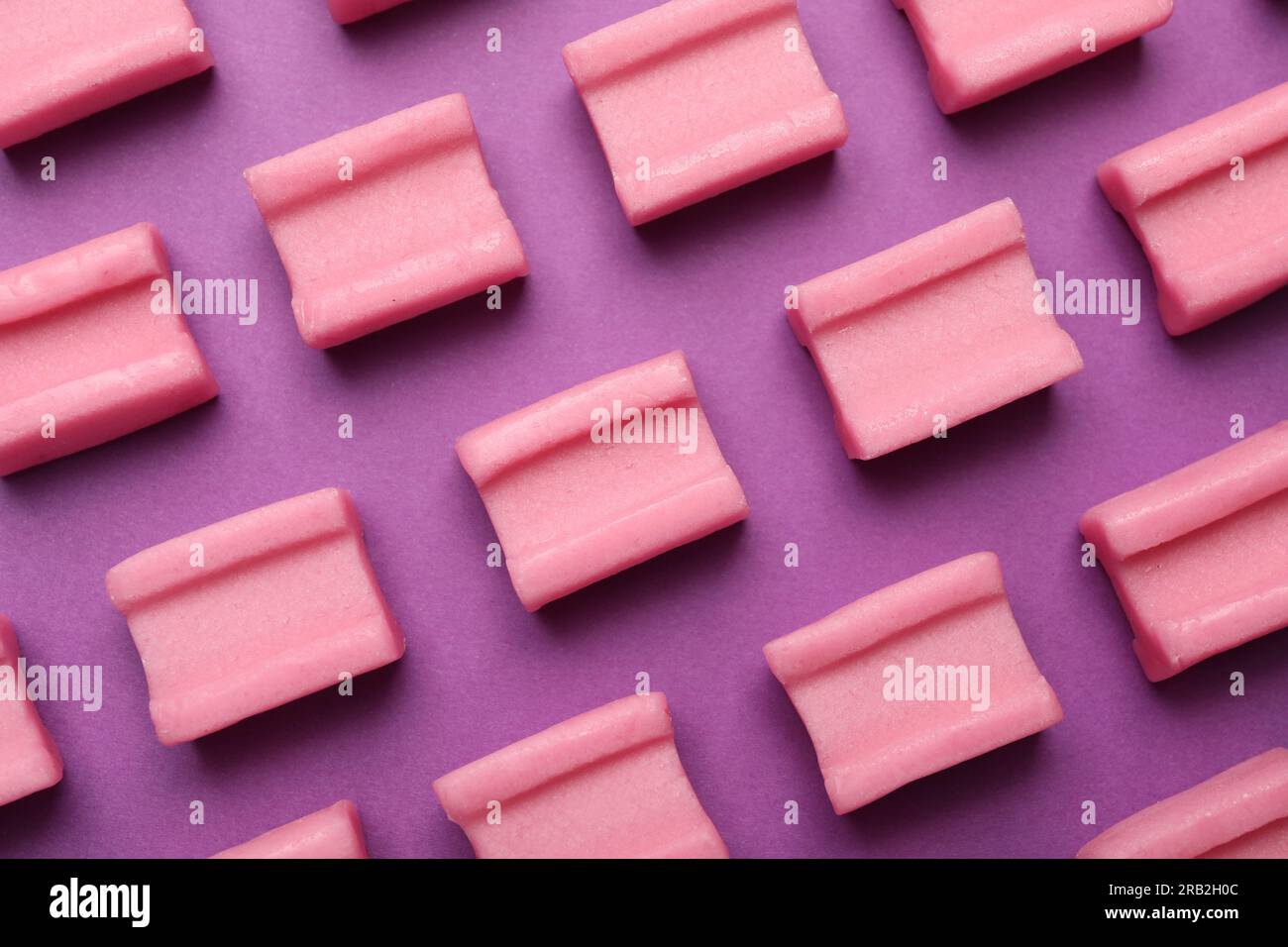 Tasty pink chewing gums on purple background, flat lay Stock Photo - Alamy