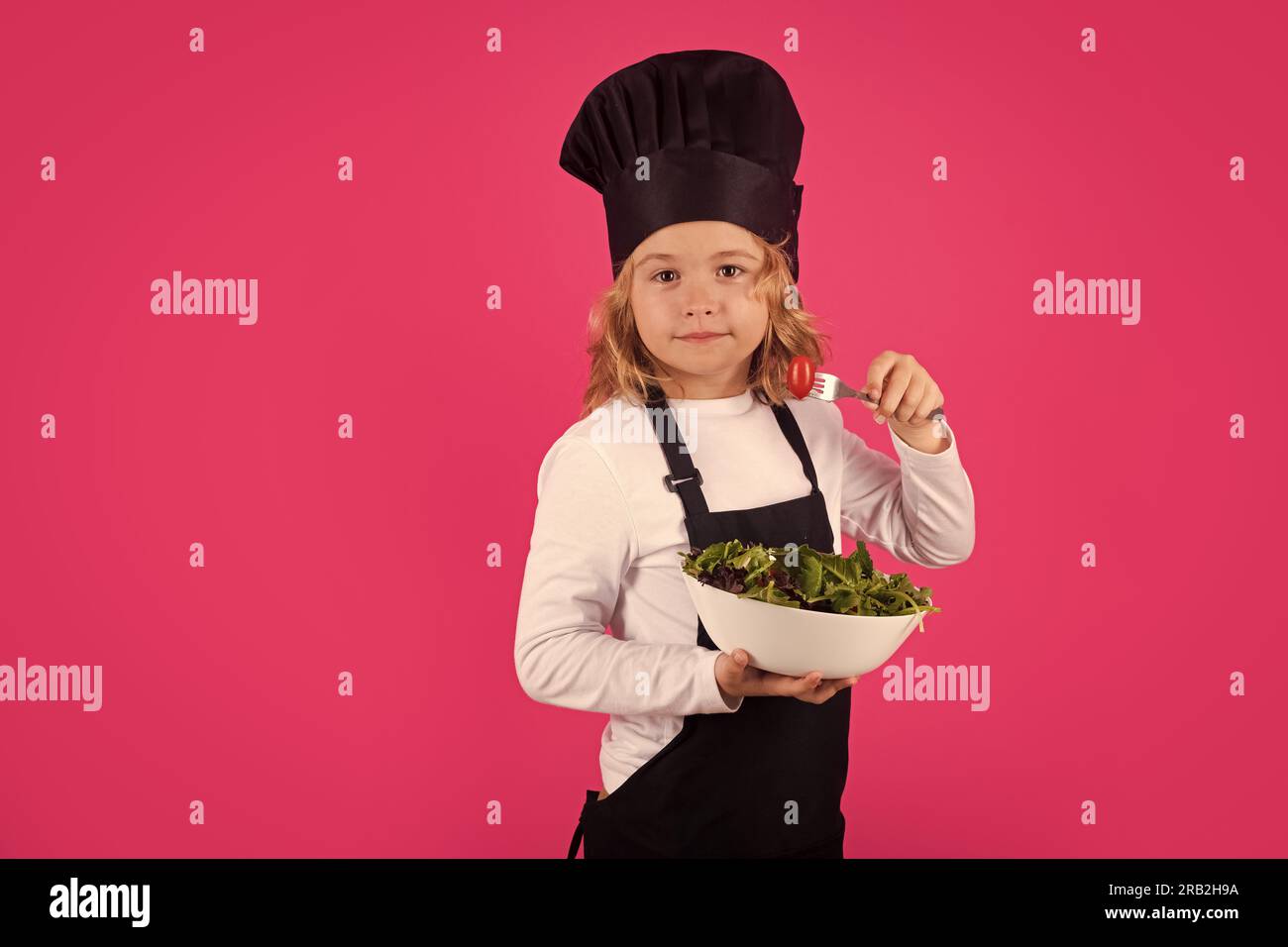 Kid cook hold plate with vegetables and fork with tomato. Cooking ...