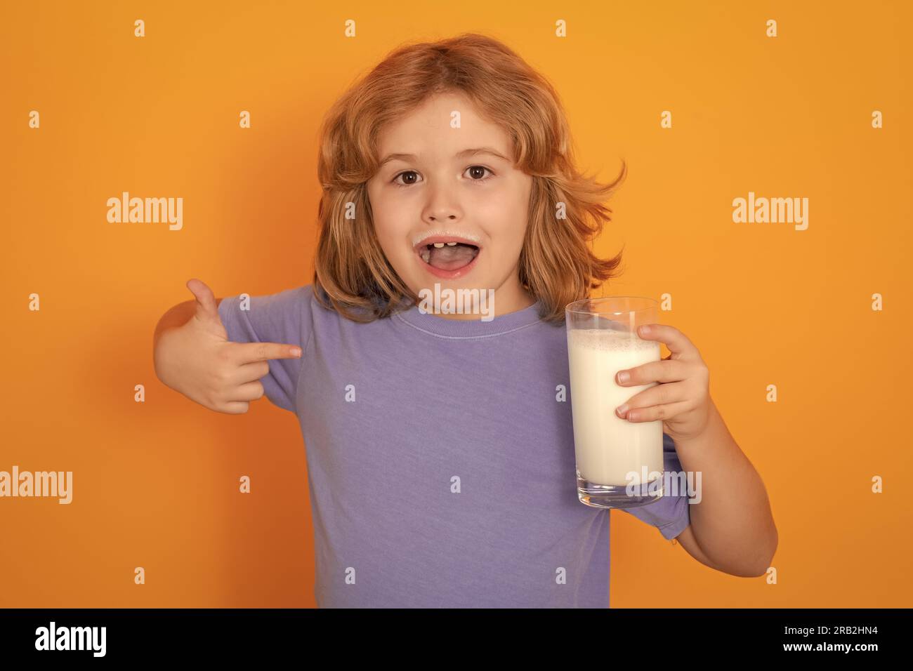 Kid boy with a glass of milk on studio background. Cute child in white ...