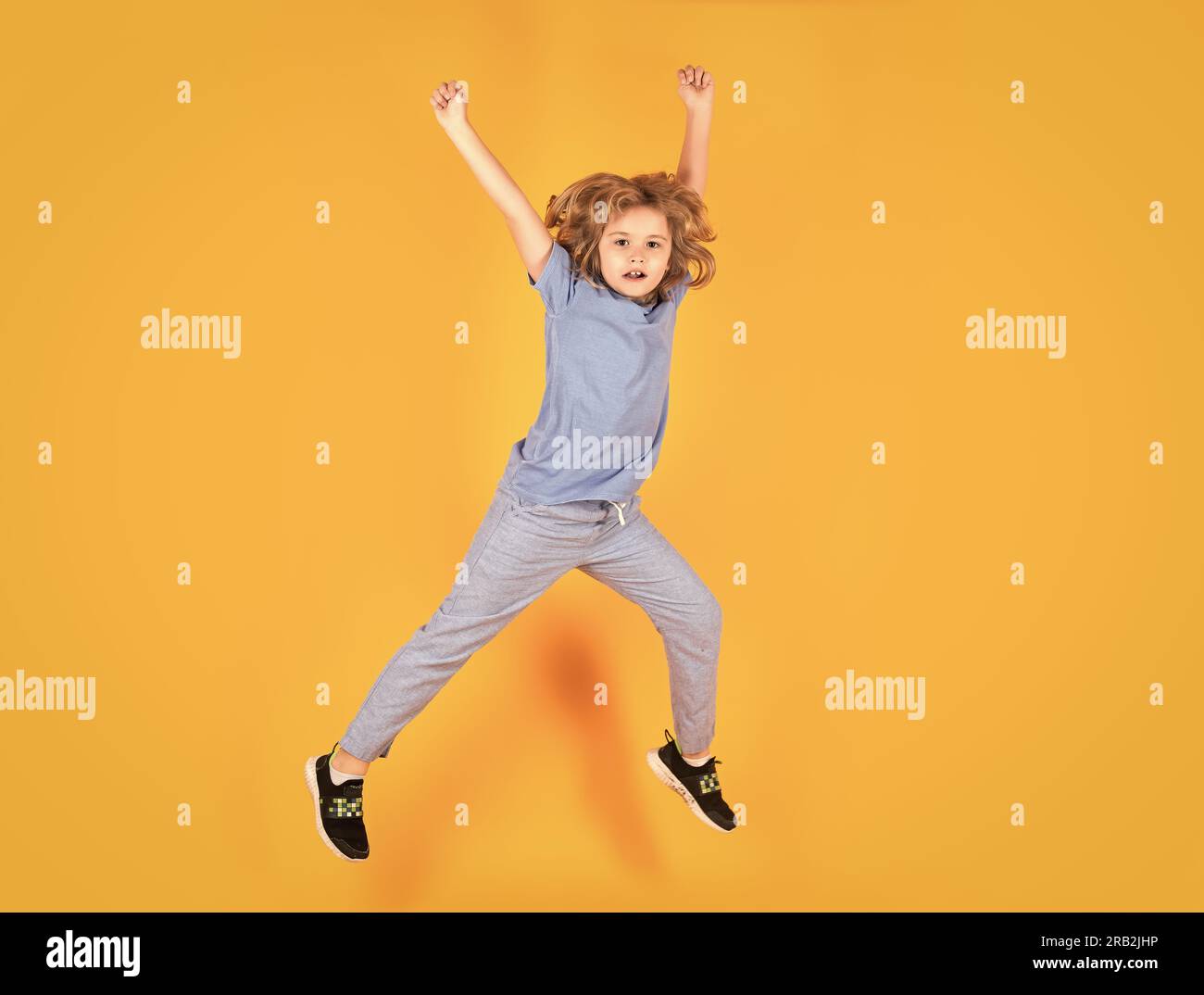 Boy jumping. Full size of kid boy have fun jump up isolated over yellow ...
