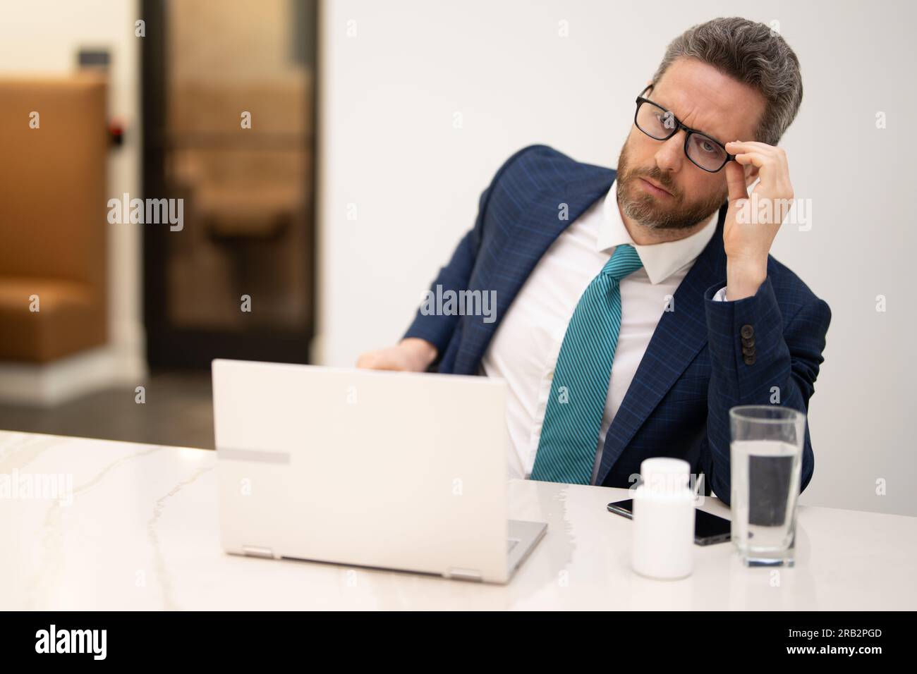 Business man suffering from headache after computer work, exhausted ...