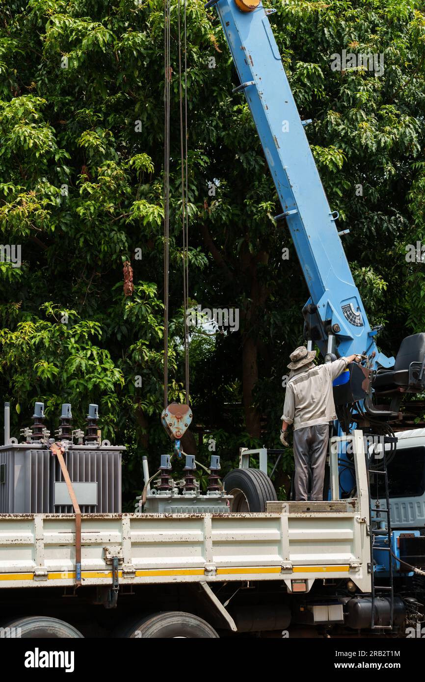 worker using crane hook lifts up the distribution transformer Stock ...