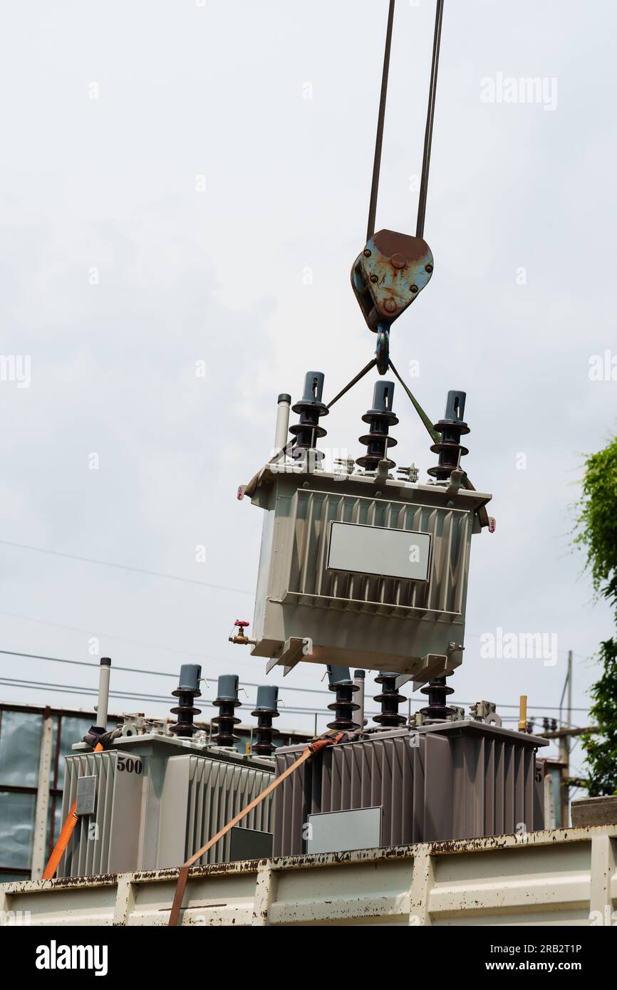 crane hook lifts up the distribution transformer Stock Photo - Alamy