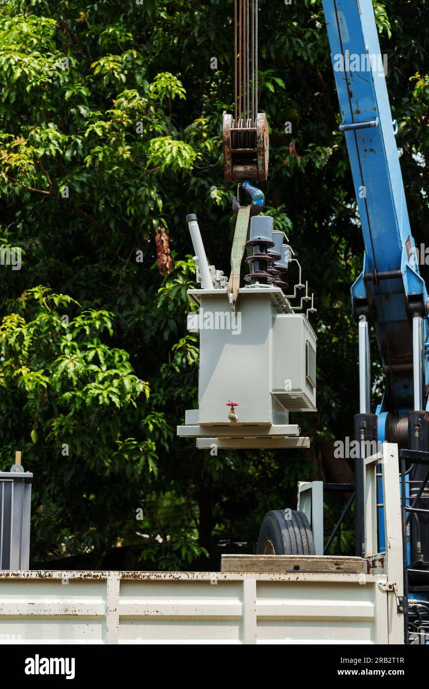crane hook lifts up the distribution transformer Stock Photo - Alamy
