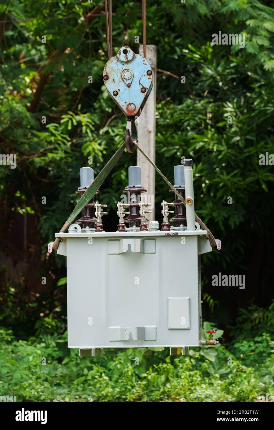 crane hook lifts up the distribution transformer Stock Photo - Alamy