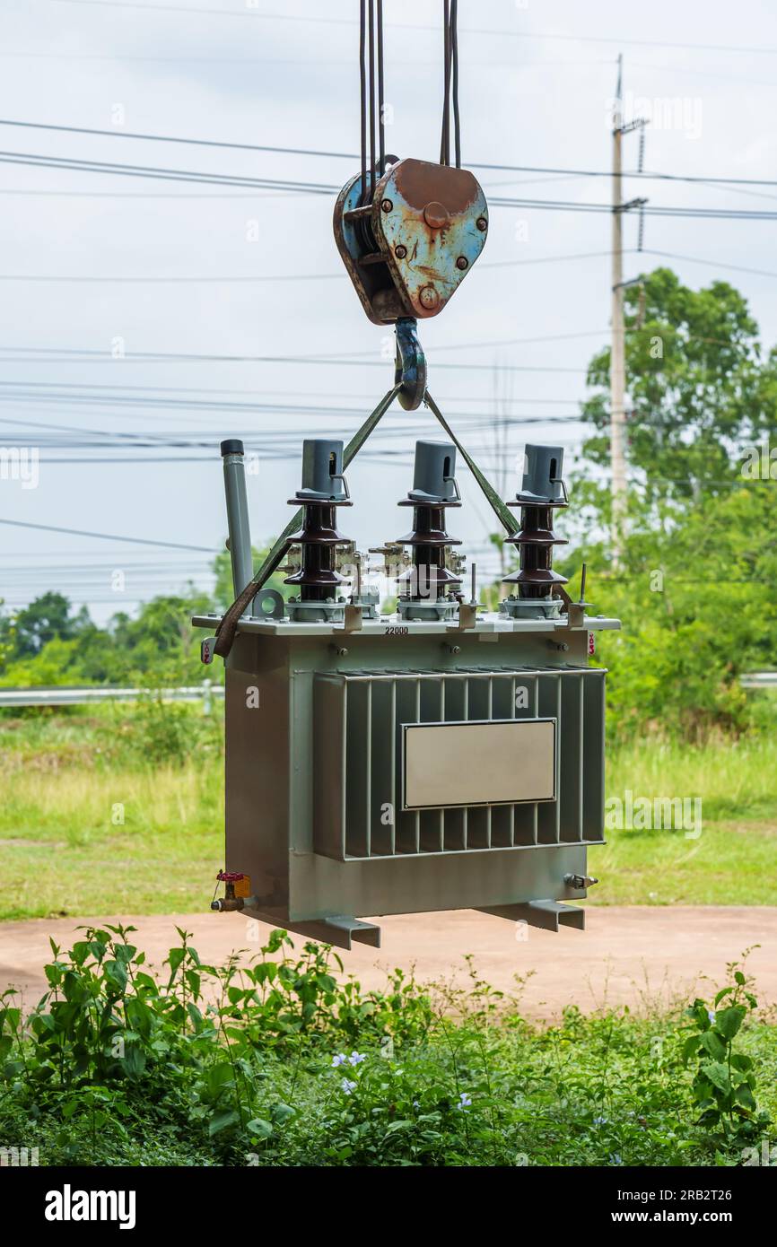 crane hook lifts up the distribution transformer Stock Photo - Alamy