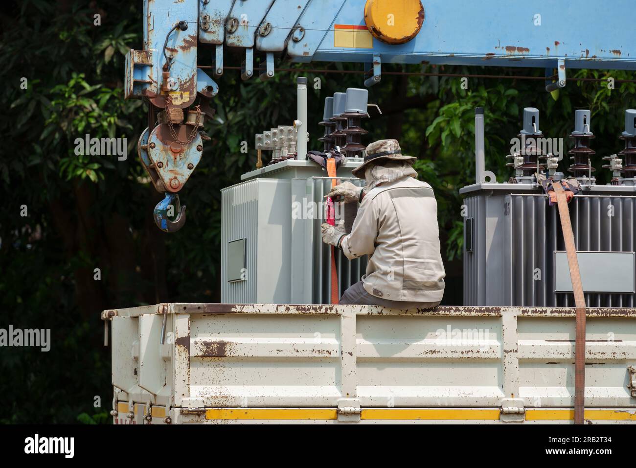worker strapping power transformer on a truck Stock Photo - Alamy