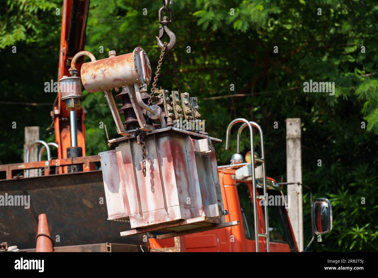 crane hook lifts up the old distribution transformer Stock Photo - Alamy
