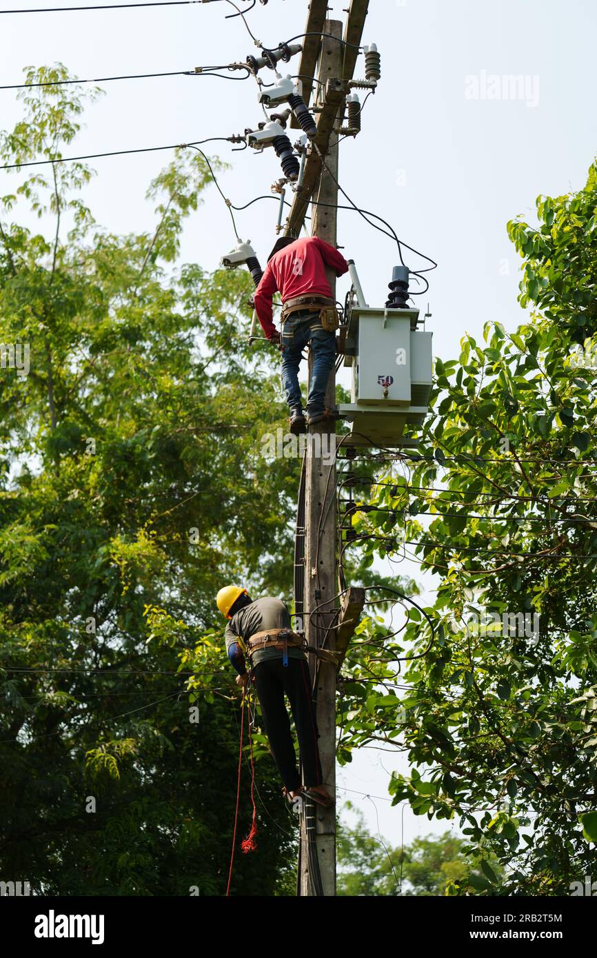 worker install a three-phase current transformer on the electric pole ...