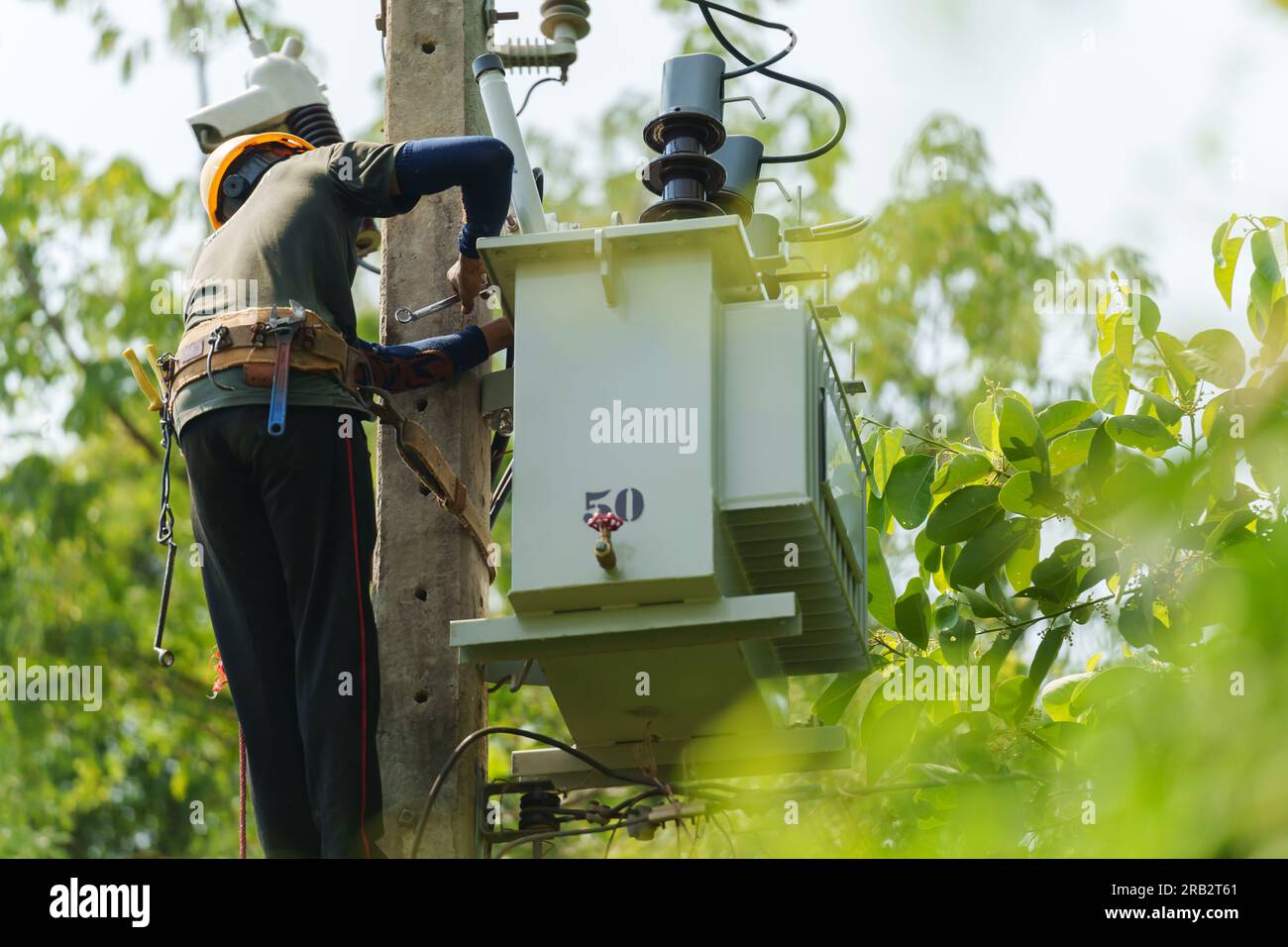 worker install a three-phase current transformer on the electric pole ...