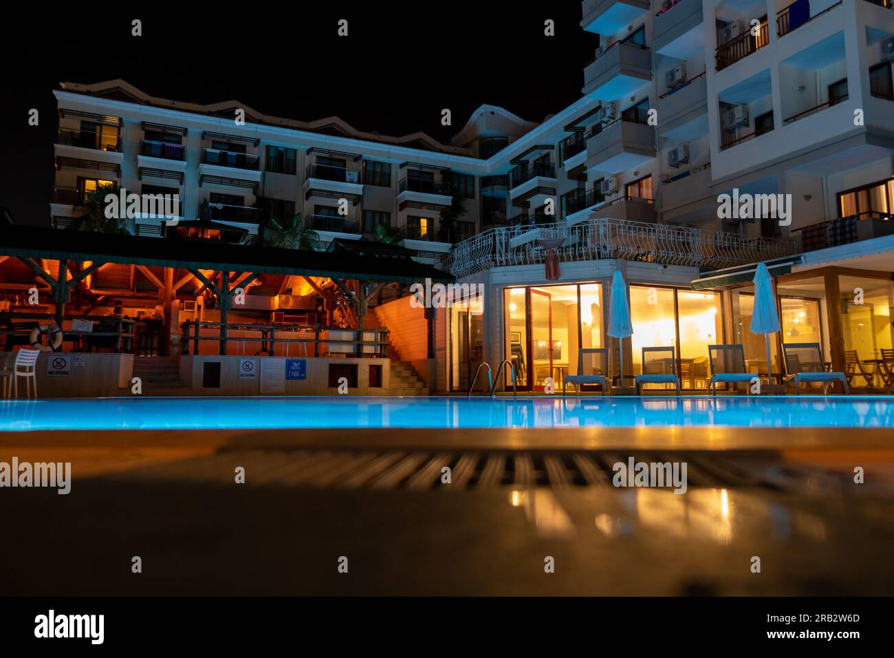 Beautiful hotel illuminated at night near the blue pool Stock Photo - Alamy