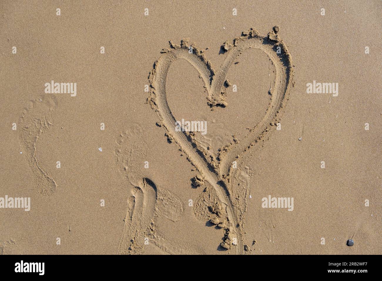 Heart shape and footprint on wet sand Stock Photo - Alamy