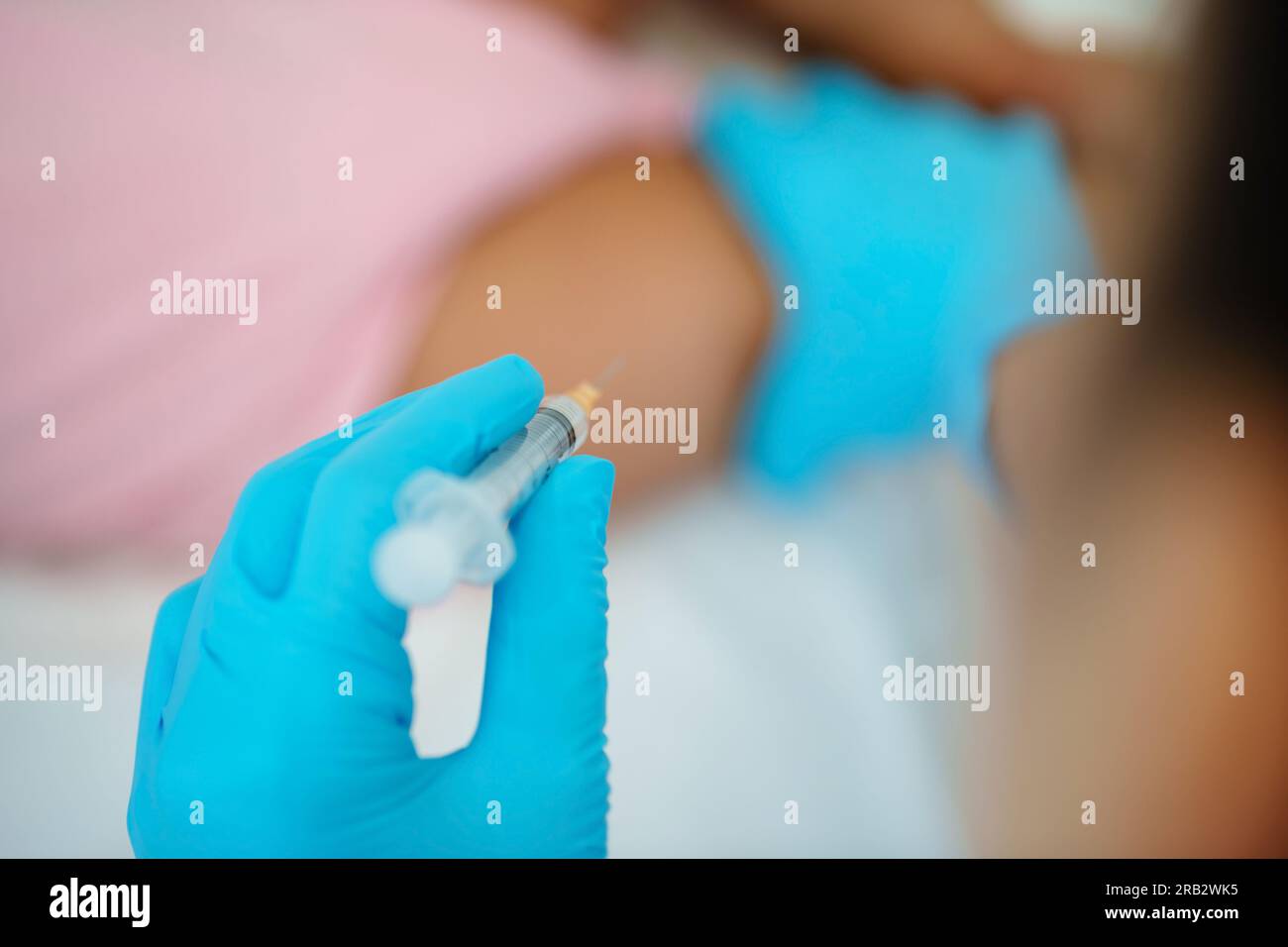 doctor holding syringe and preparing vaccine giving injection to leg of ...