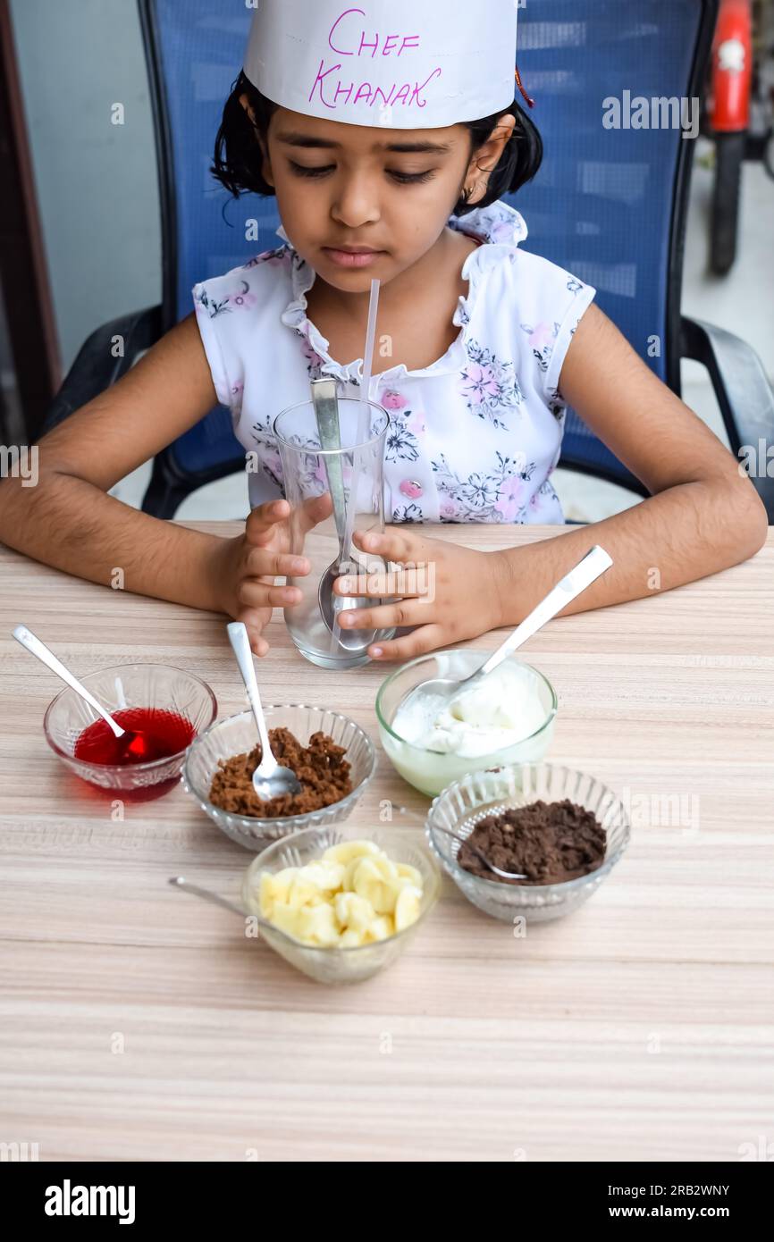 Cute Indian chef girl preparing sundae dish as a part of non fire ...