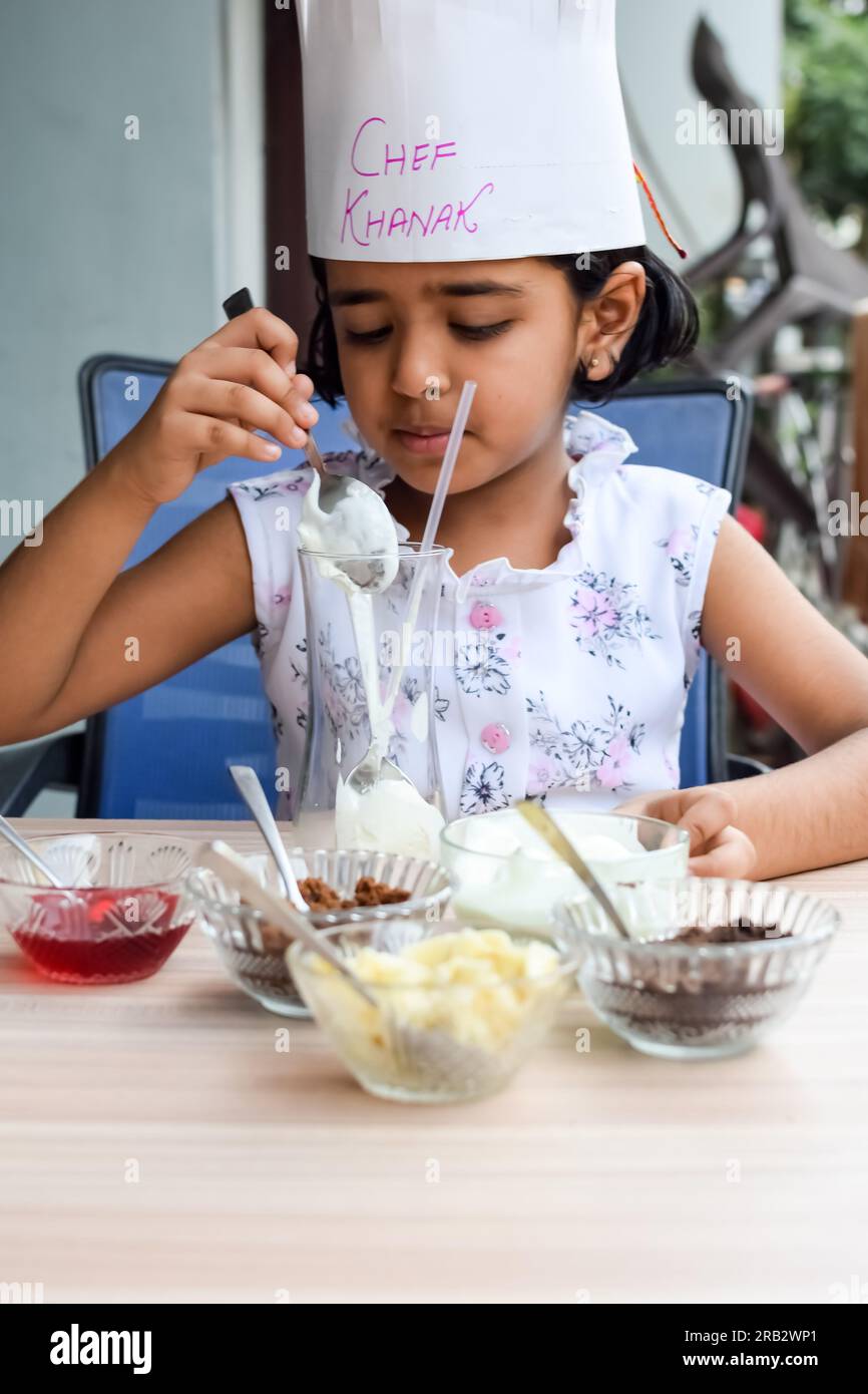 Cute Indian chef girl preparing sundae dish as a part of non fire ...