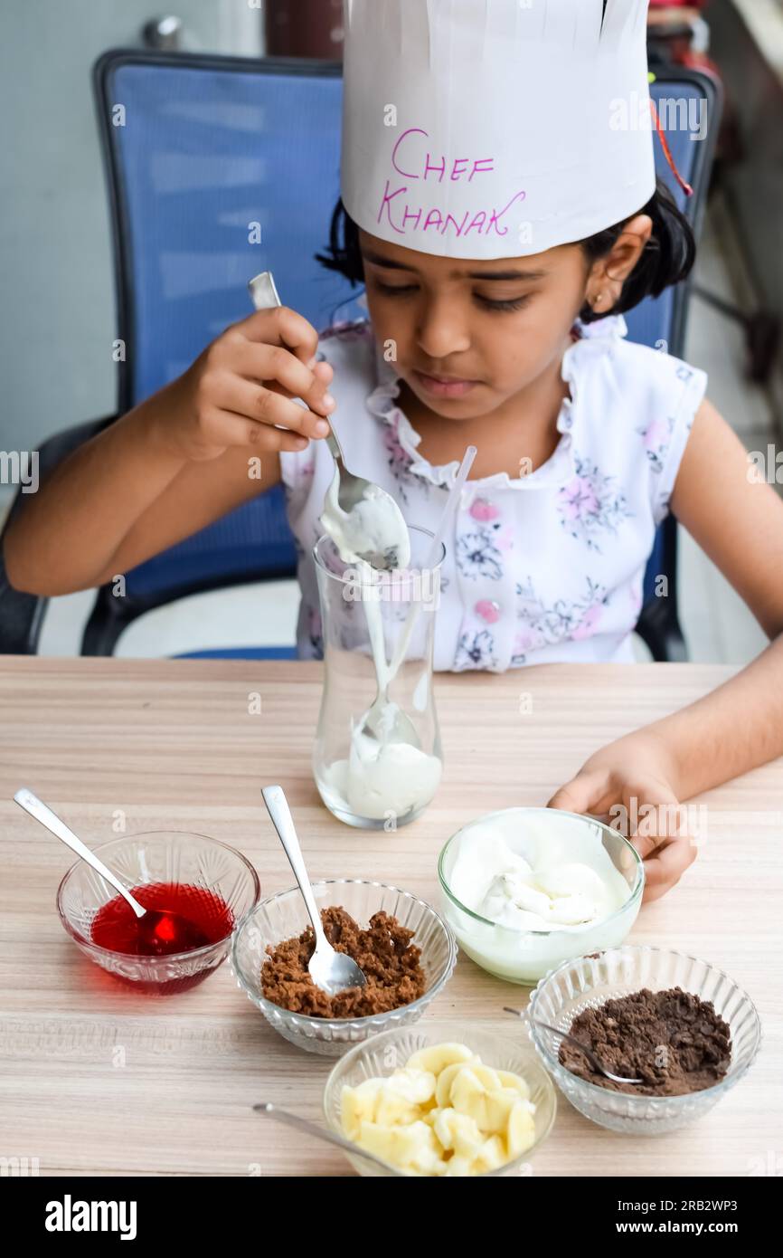 Cute Indian chef girl preparing sundae dish as a part of non fire ...