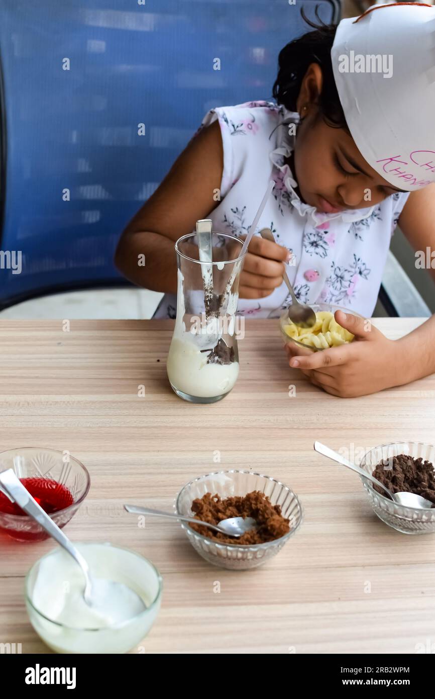 Cute Indian chef girl preparing sundae dish as a part of non fire ...