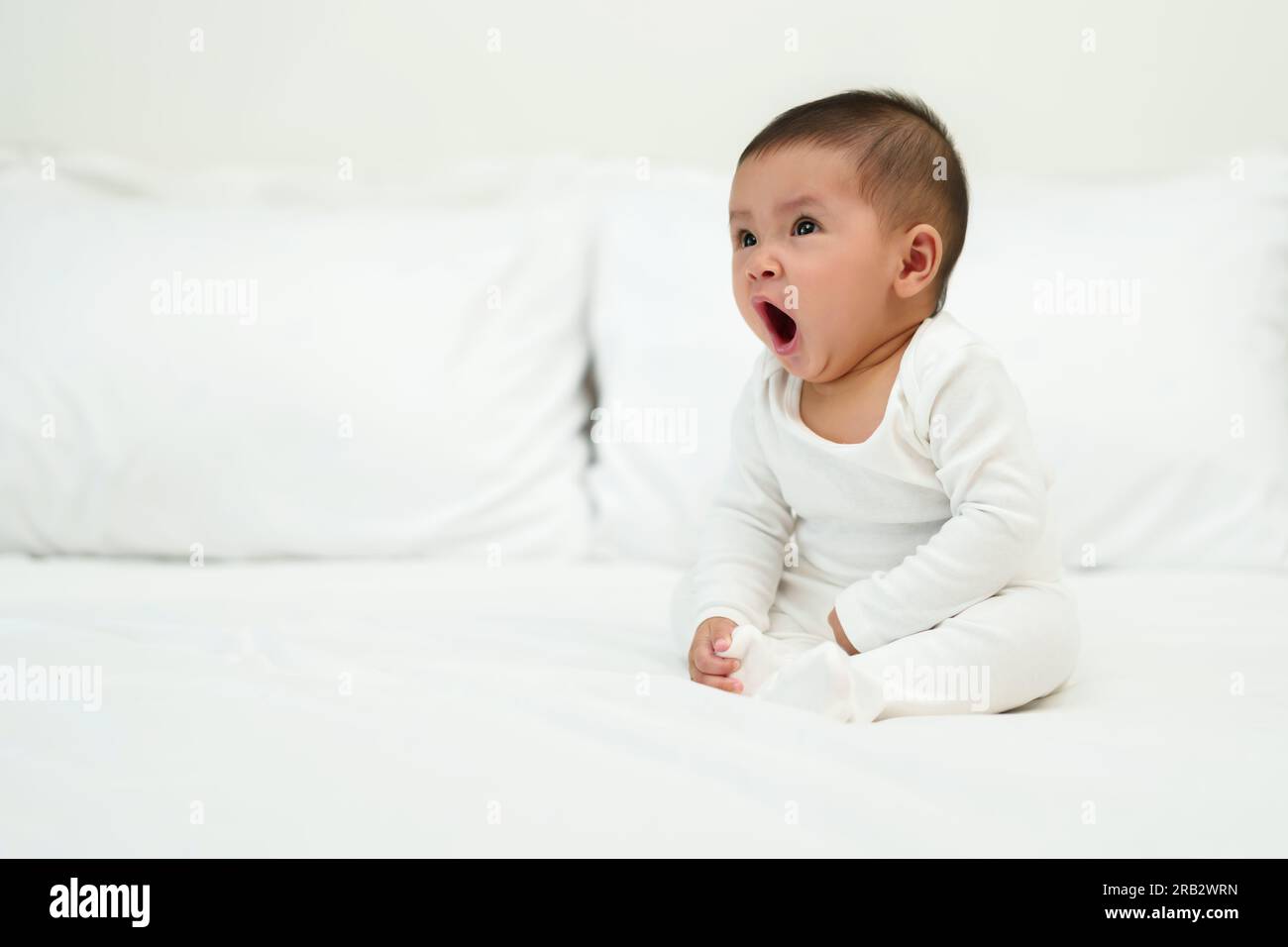 Infant girl sitting on a bed hi-res stock photography and images - Alamy