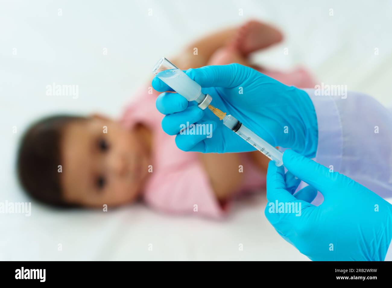 doctor drawing syringe and preparing vaccine giving injection to infant ...