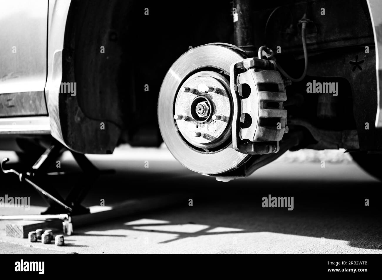 Wheel well of a vehicle lifted with a tire jack. Rusted hub and strut ...