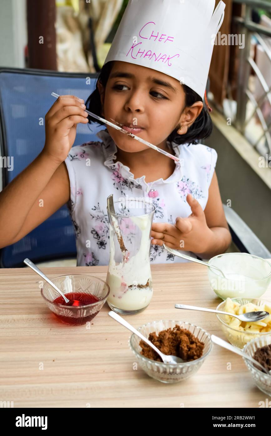 Cute Indian chef girl preparing sundae dish as a part of non fire ...