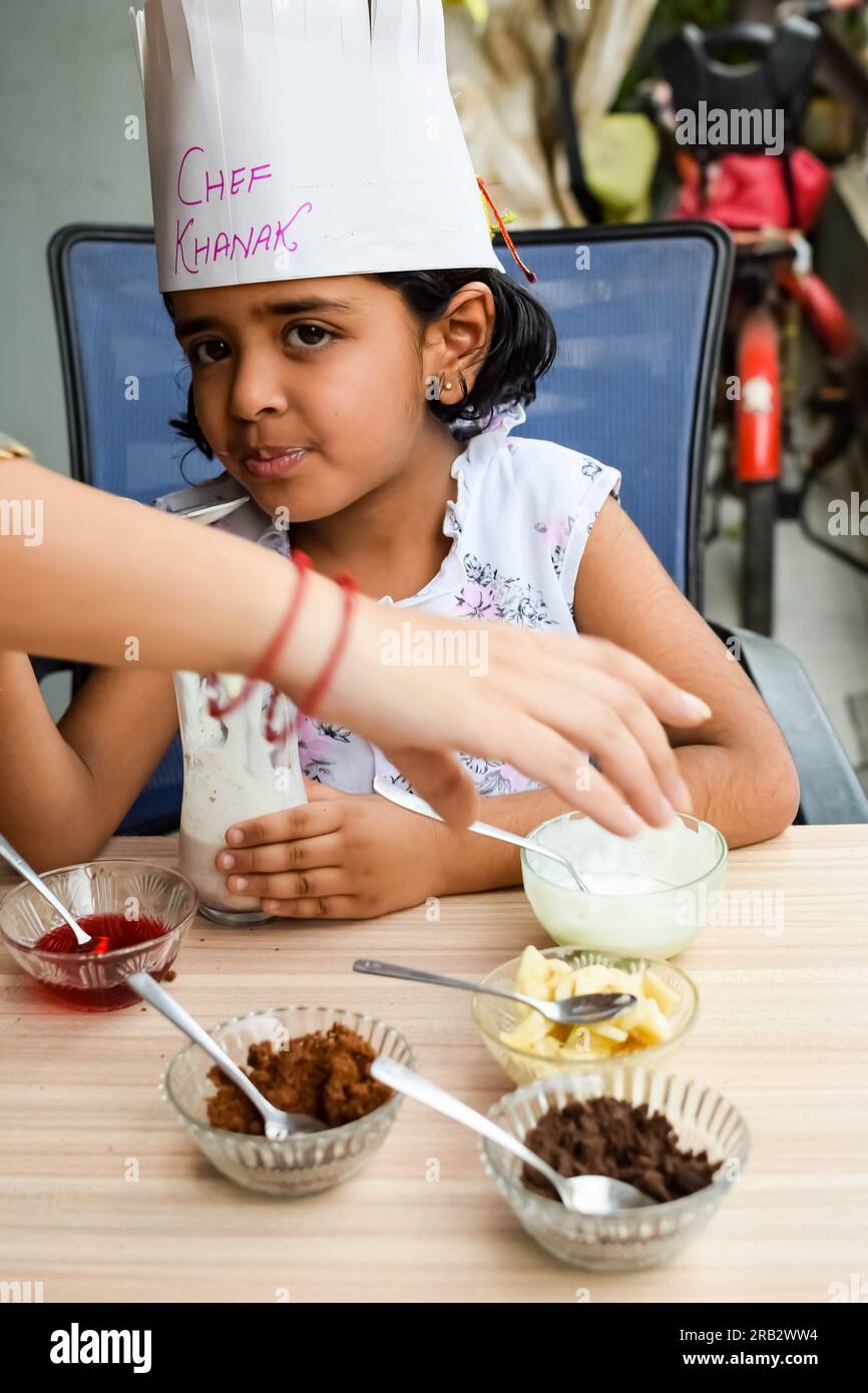 Cute Indian chef girl preparing sundae dish as a part of non fire ...