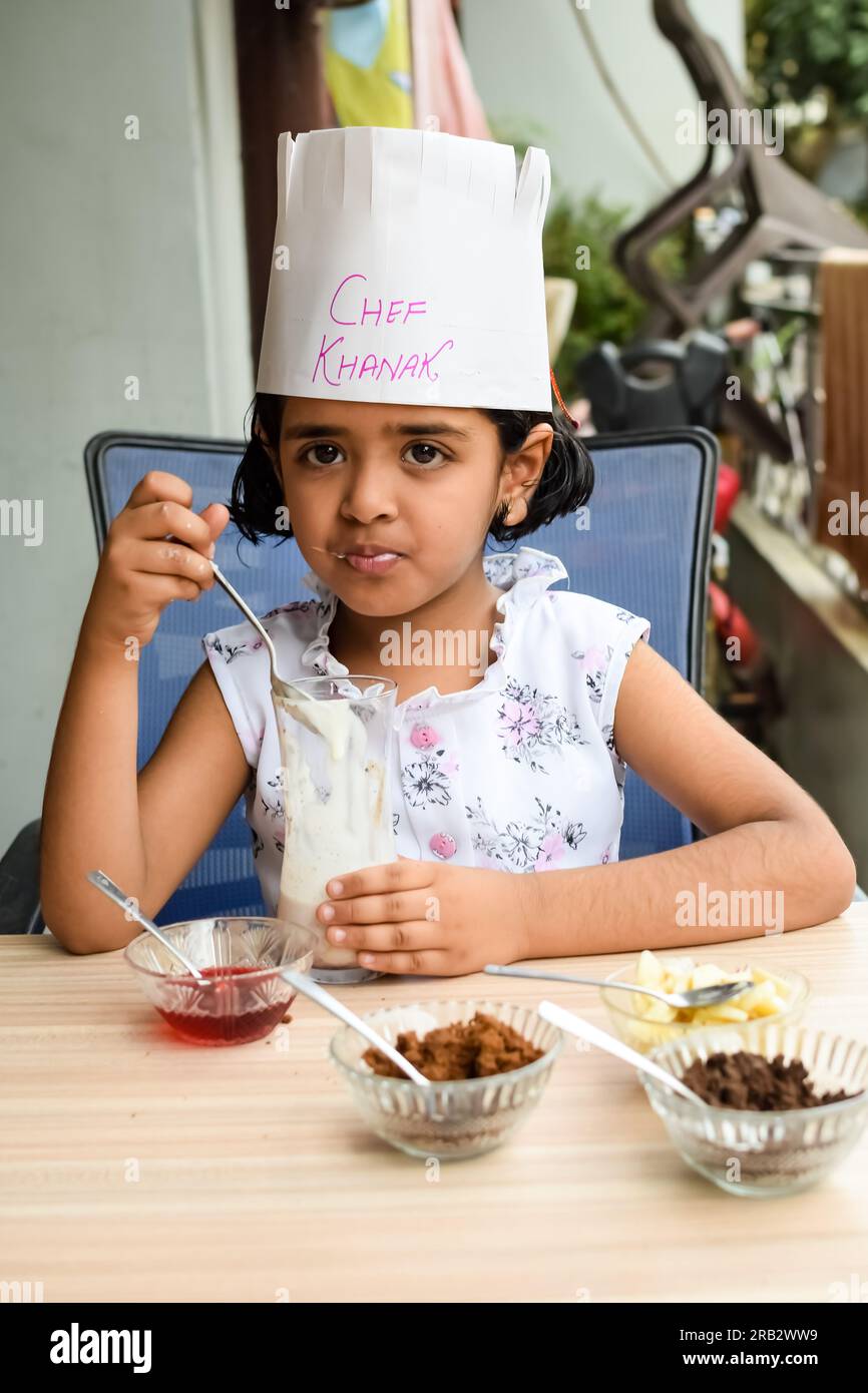 Cute Indian chef girl preparing sundae dish as a part of non fire ...