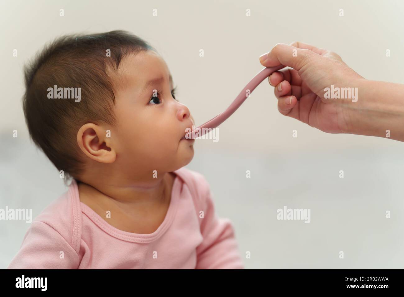 mother feeding a liquid medicine to sick infant baby with spoon Stock ...