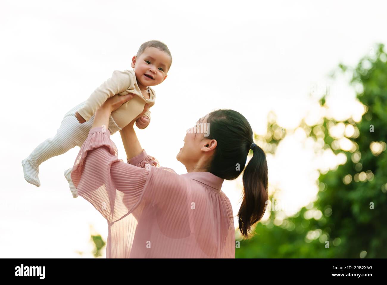 Mother lifting beautiful baby outdoor hi-res stock photography and ...