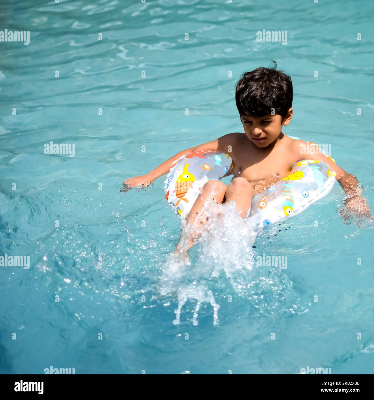 Happy Indian boy swimming in a pool, Kid wearing swimming costume along ...