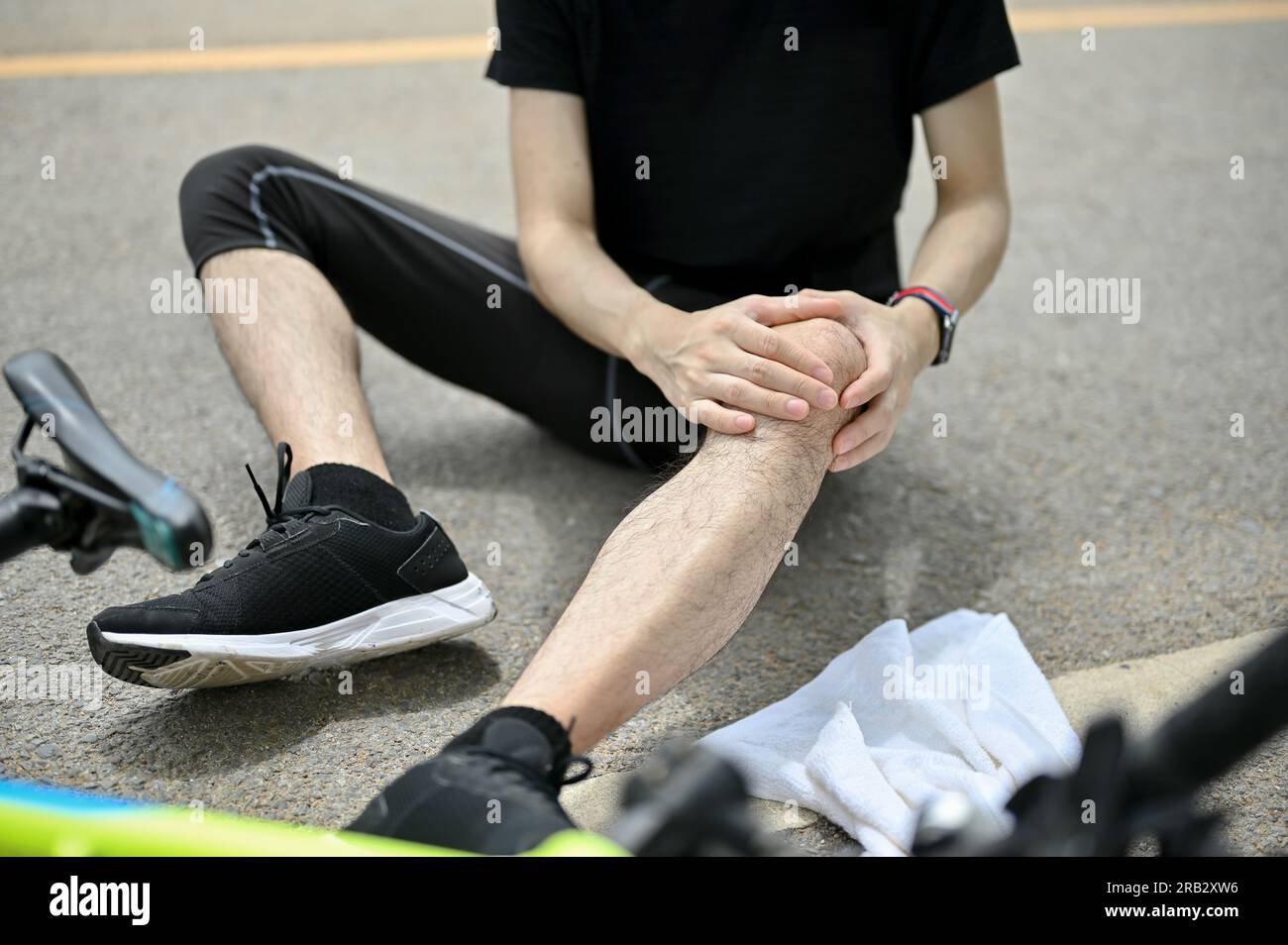 Close-up image of an injured male cyclist in sportswear fell off the ...
