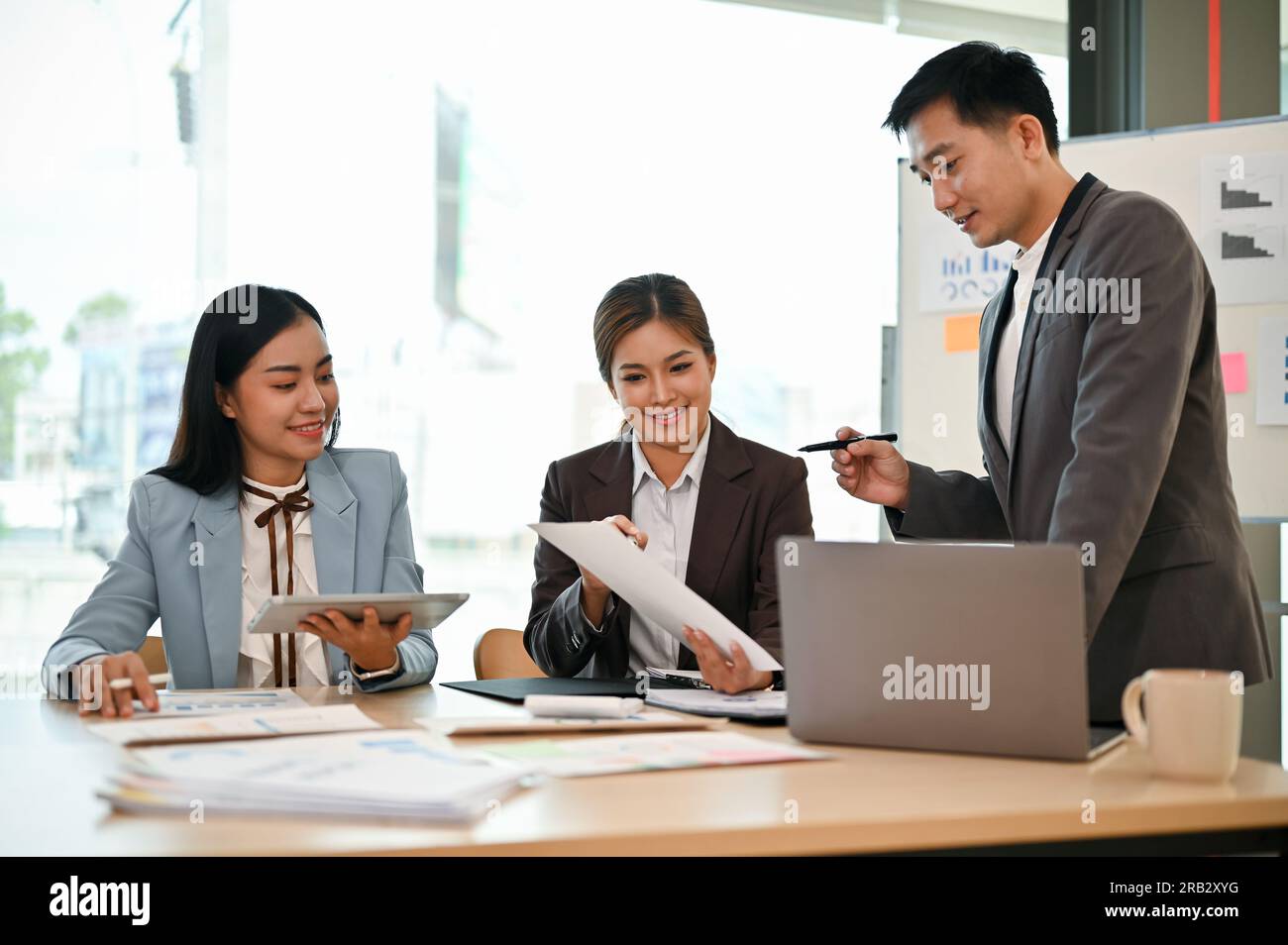 A professional millennial Asian male boss is coaching and discussing a ...