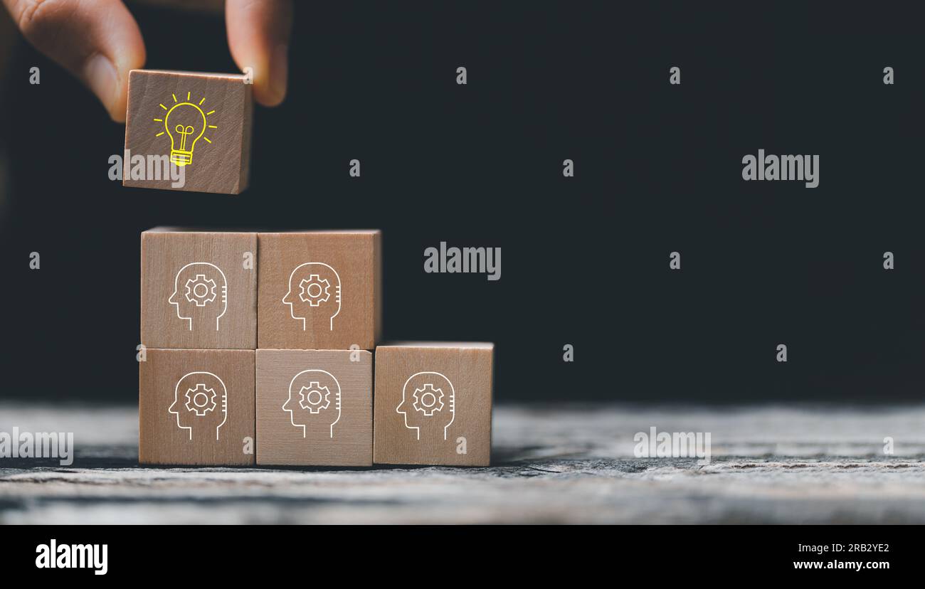 Concept creative idea and innovation. Hand choose wooden cube block with head human symbol and ...